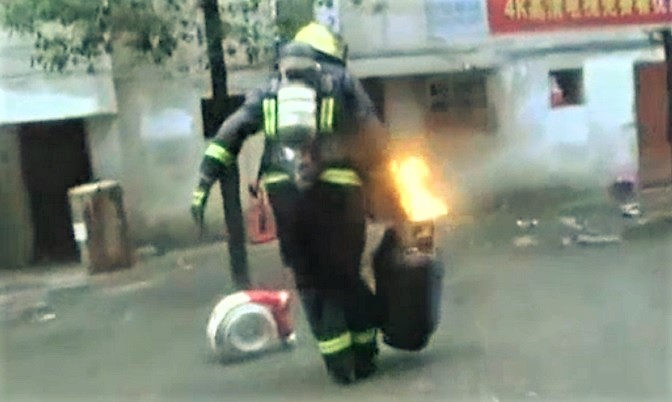 Caught on camera: Firefighters walks flaming propane tank down 5 floors ...